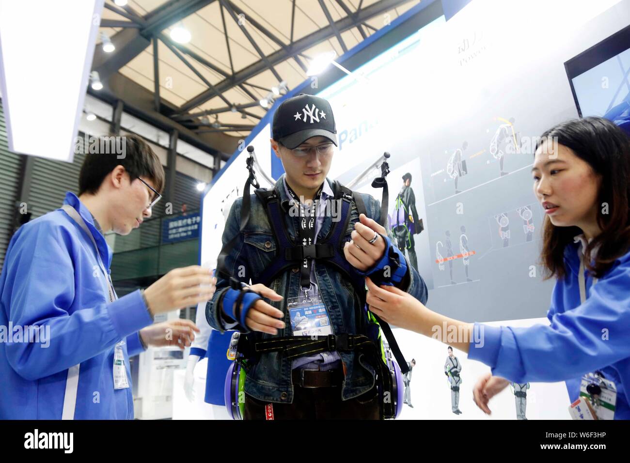 A visitor tries out a robotic exoskeleton during the Electronica China ...
