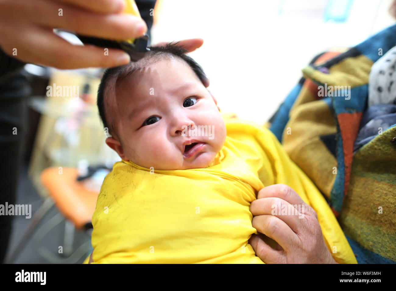 A Chinese baby has his hair cut to celebrate the Longtaitou Festival ...