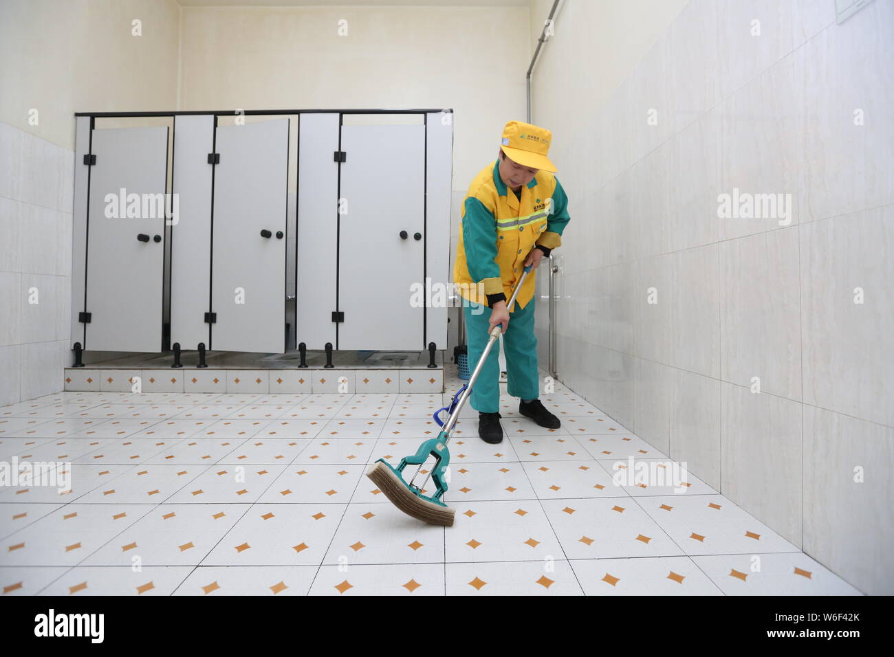 --FILE--A Chinese worker cleans a public toilet in Xi'an city ...