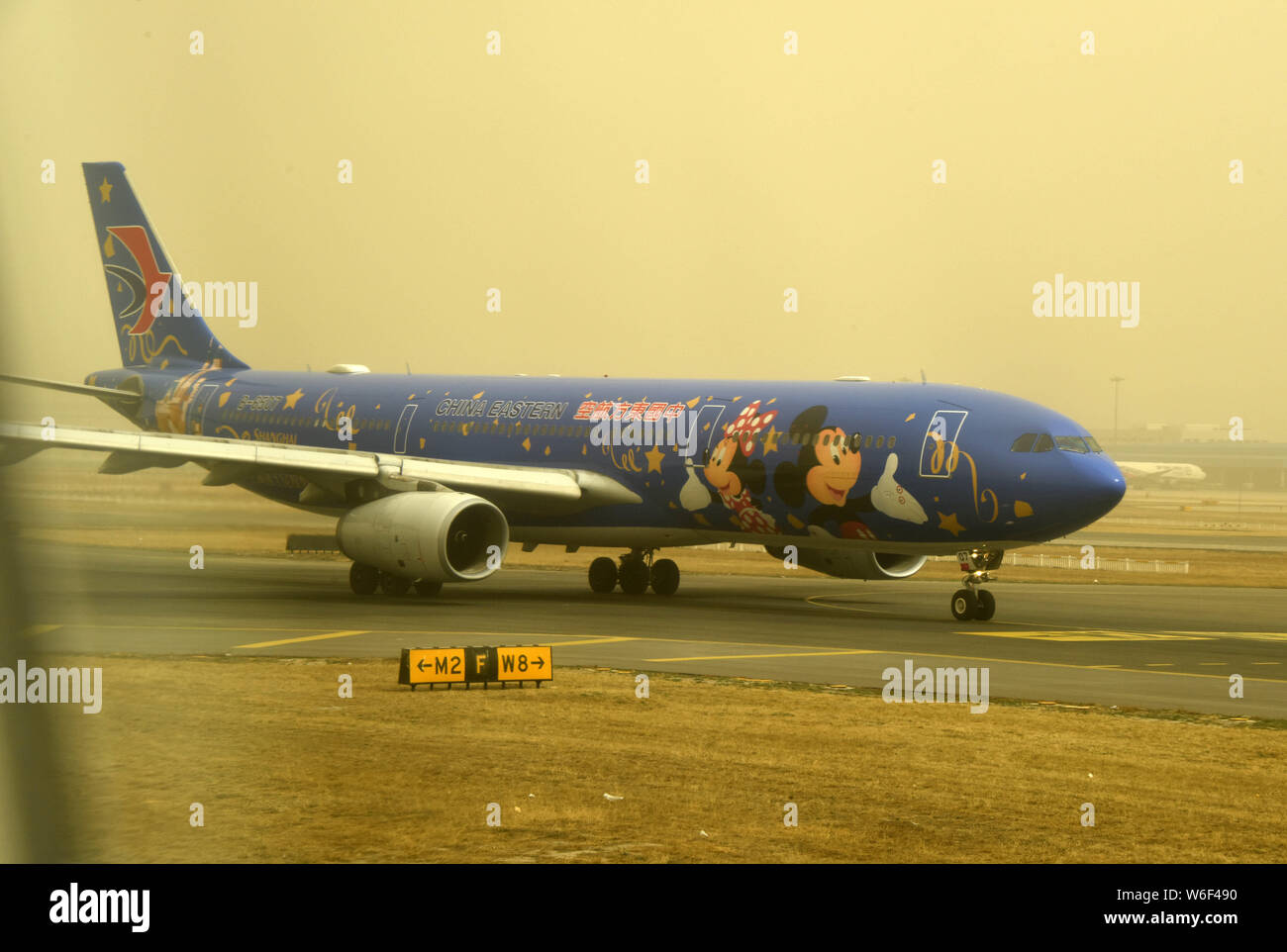 A jet plane of China Eastern Airlines with a picture of Mickey Mouse ...