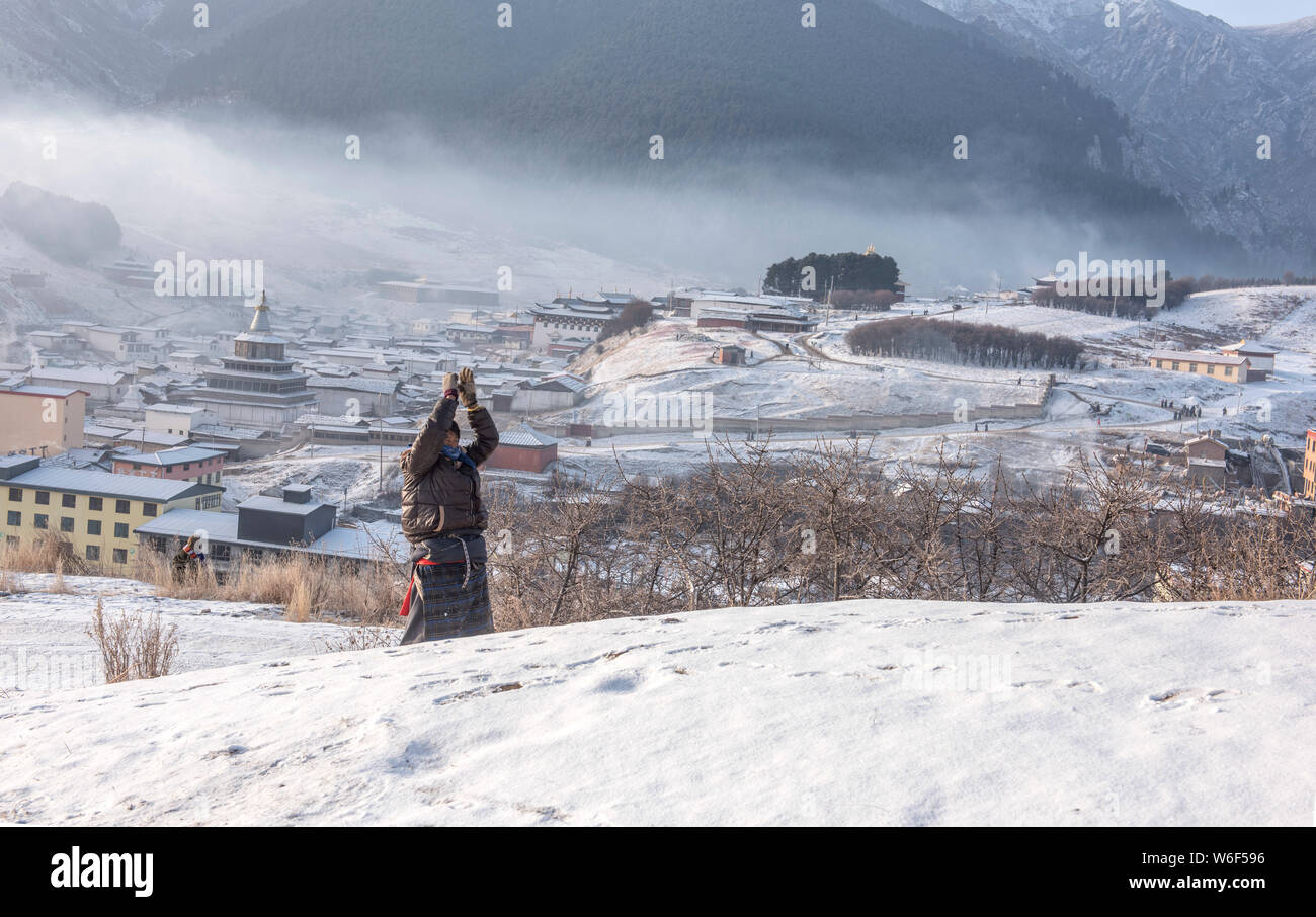 A local resident is on his way to the Langmu Temple covered by snow in ...