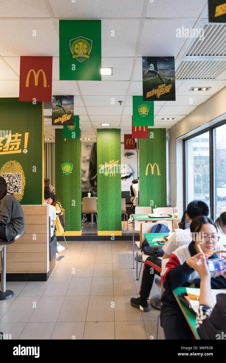 Chinese customers eat food at a green- and Beijing Guoan FC-themed ...