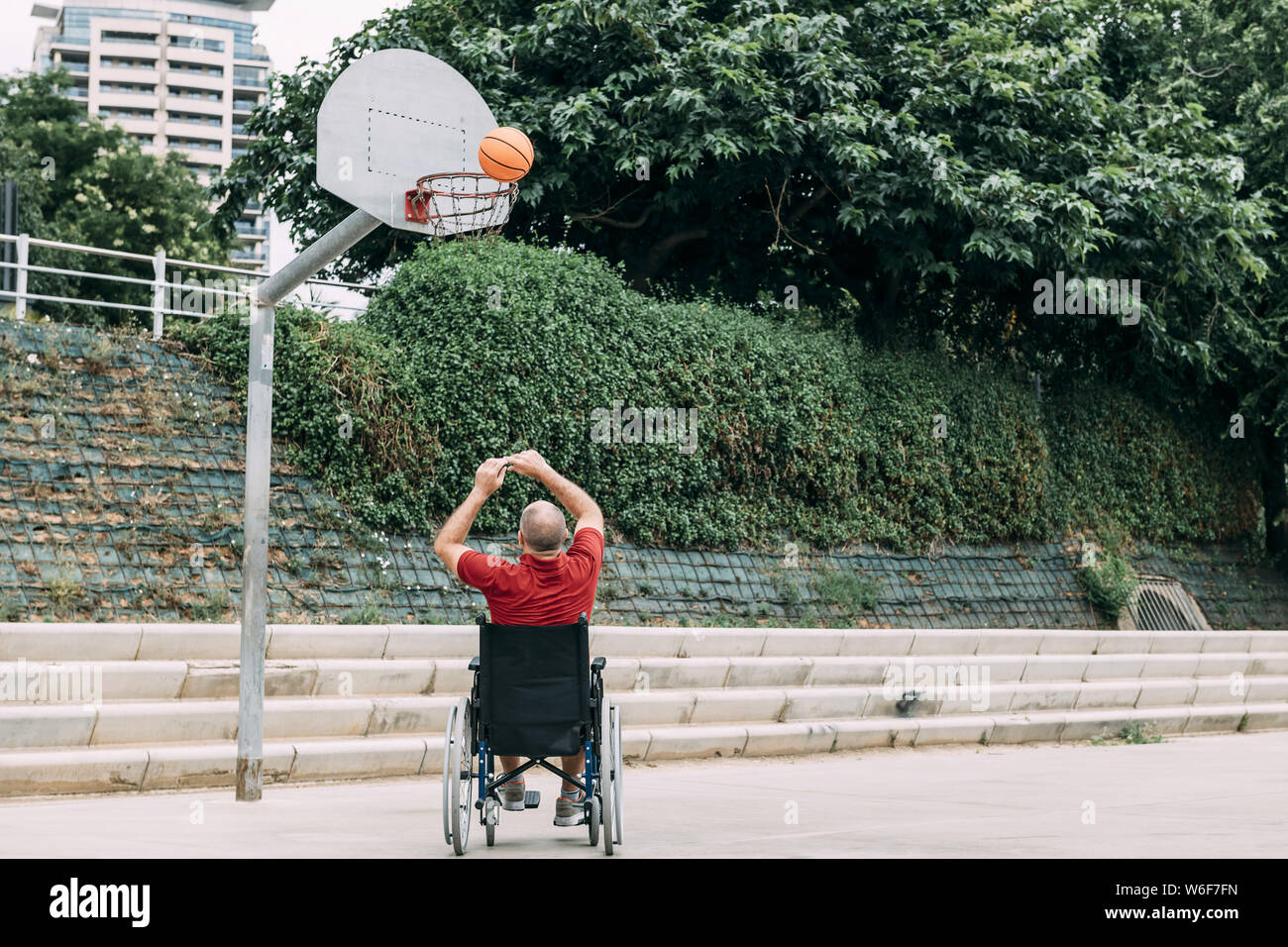handicapped man playing basketball alone in the city, concept of ...