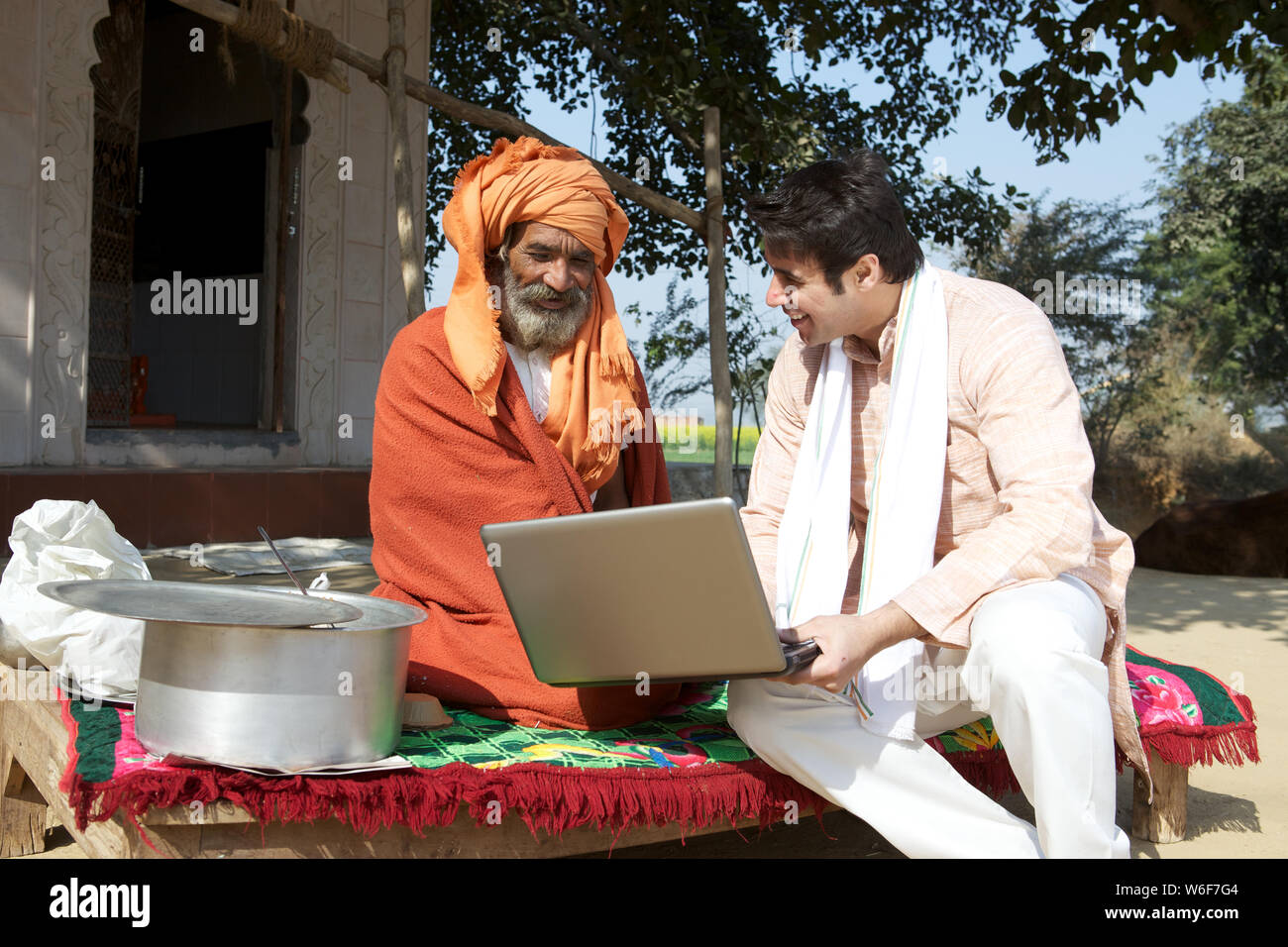 Man explaining to old man with a laptop Stock Photo - Alamy