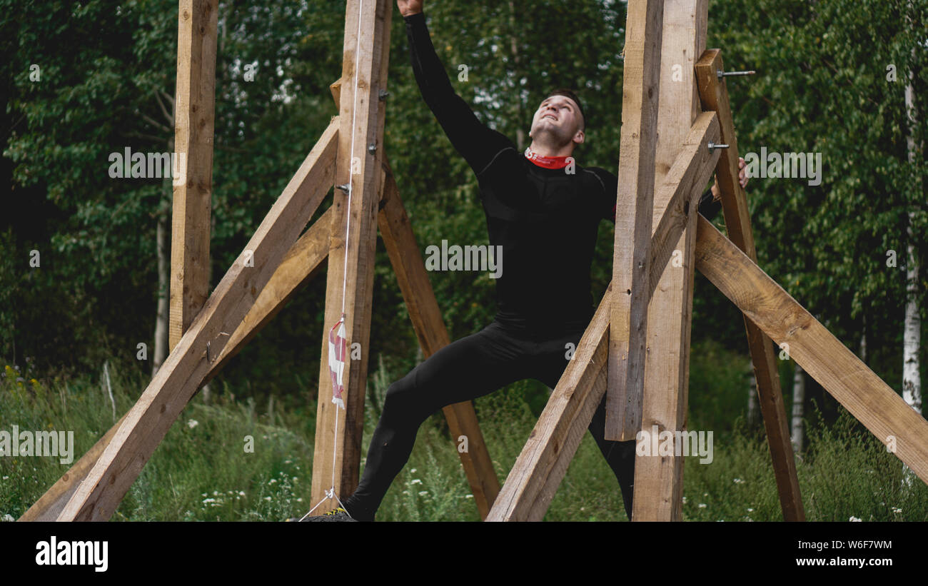 Man passing through hurdles during obstacle course in boot or sport ...