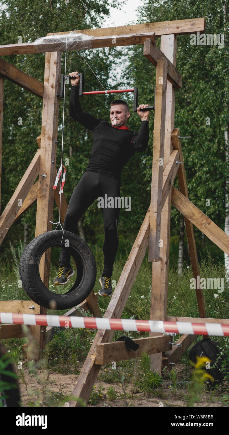 Man passing through hurdles during obstacle course in boot or sport ...