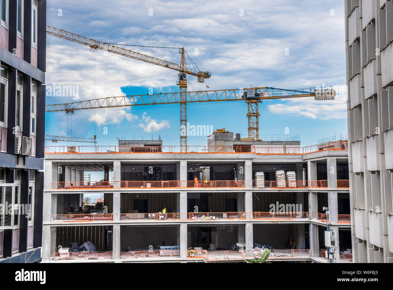 Crane Machines on top of construction building and workers inside with ...