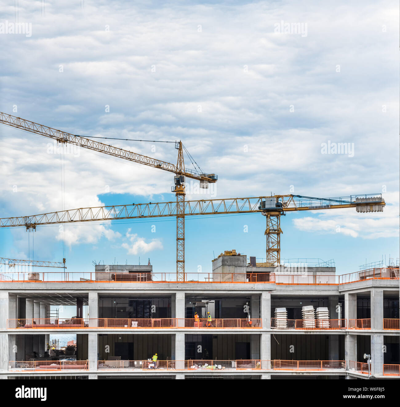Crane Machines on top of construction building and workers inside with ...