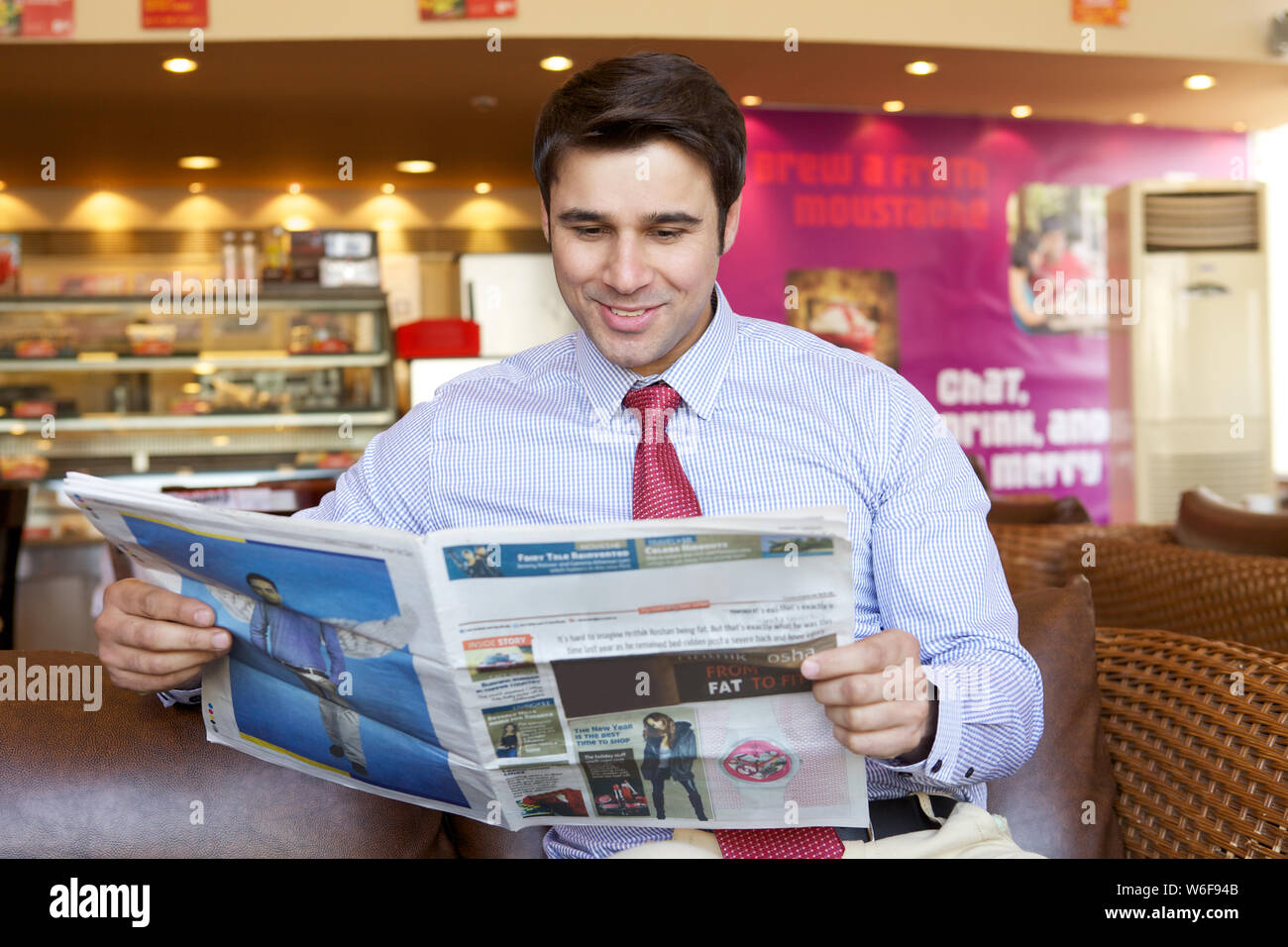 Businessman reading a newspaper in a cafeteria Stock Photo - Alamy