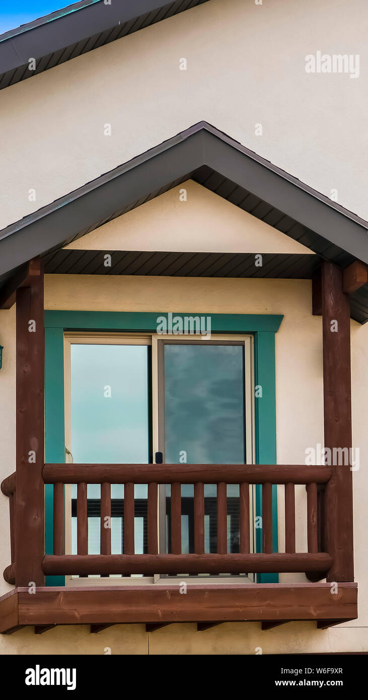Vertical frame Small balcony with brown wooden railings and posts under ...