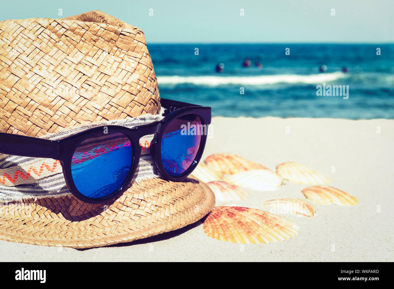 Vintage summer wicker straw beach hat and sun glasses on the sand with ...