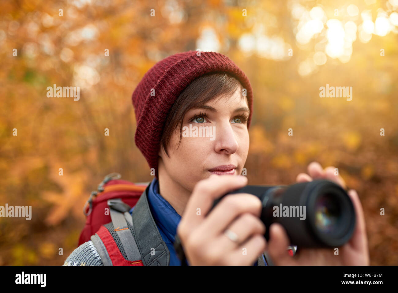 Attractive caucasian girl taking pictures with a mirrorless camera ...