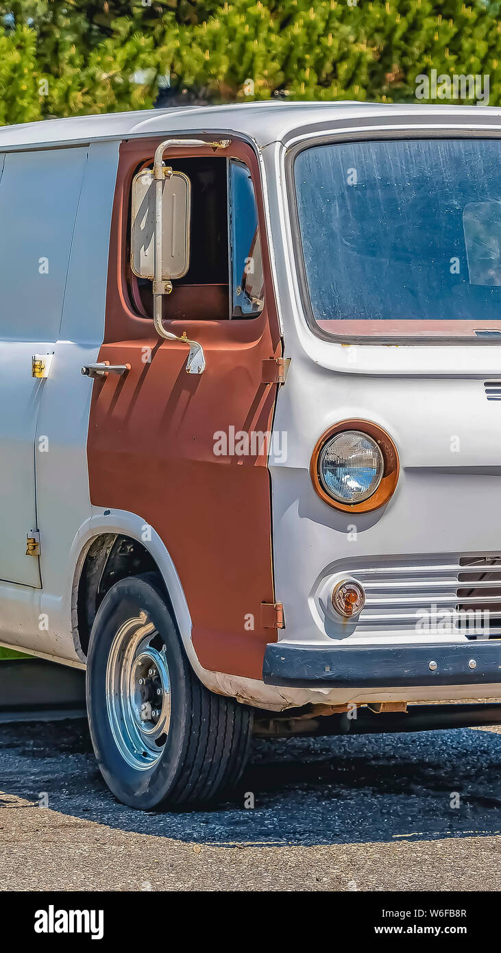 Vertical Front view of an old white van with brown door parked on ...