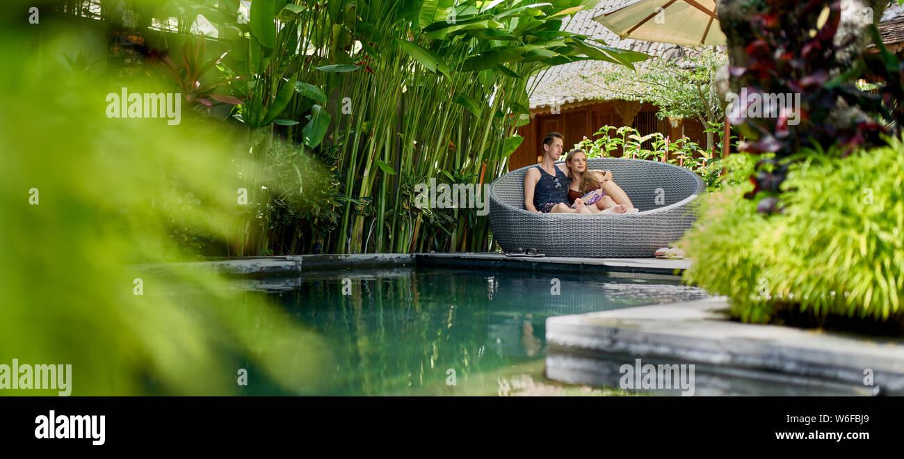 Candid shot of young caucasian couple lounging in modern chair near ...