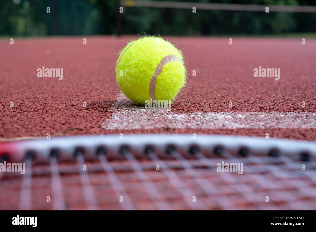 Low angle view tennis scene with ball, racquet and hard court surface ...
