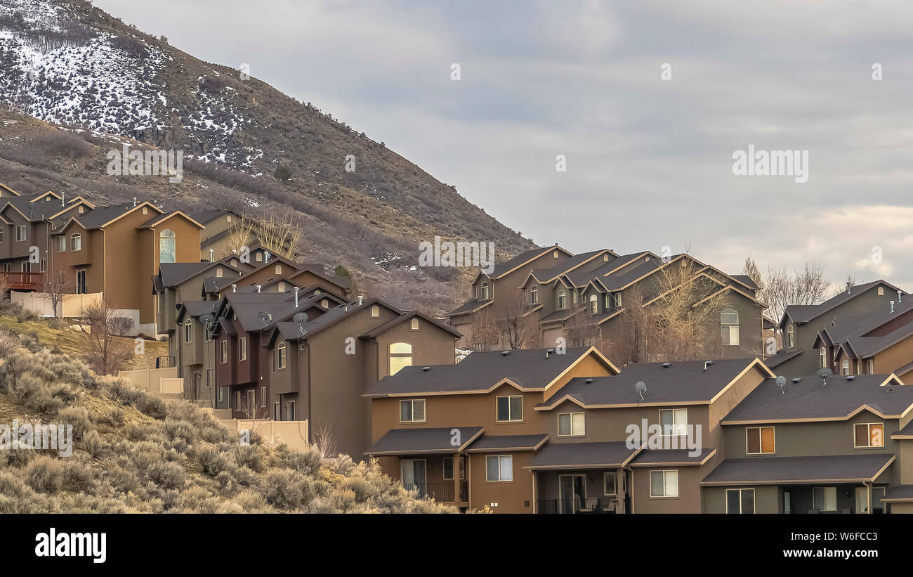 Panorama Rows of houses built on a mountain slope with view of cloudy ...