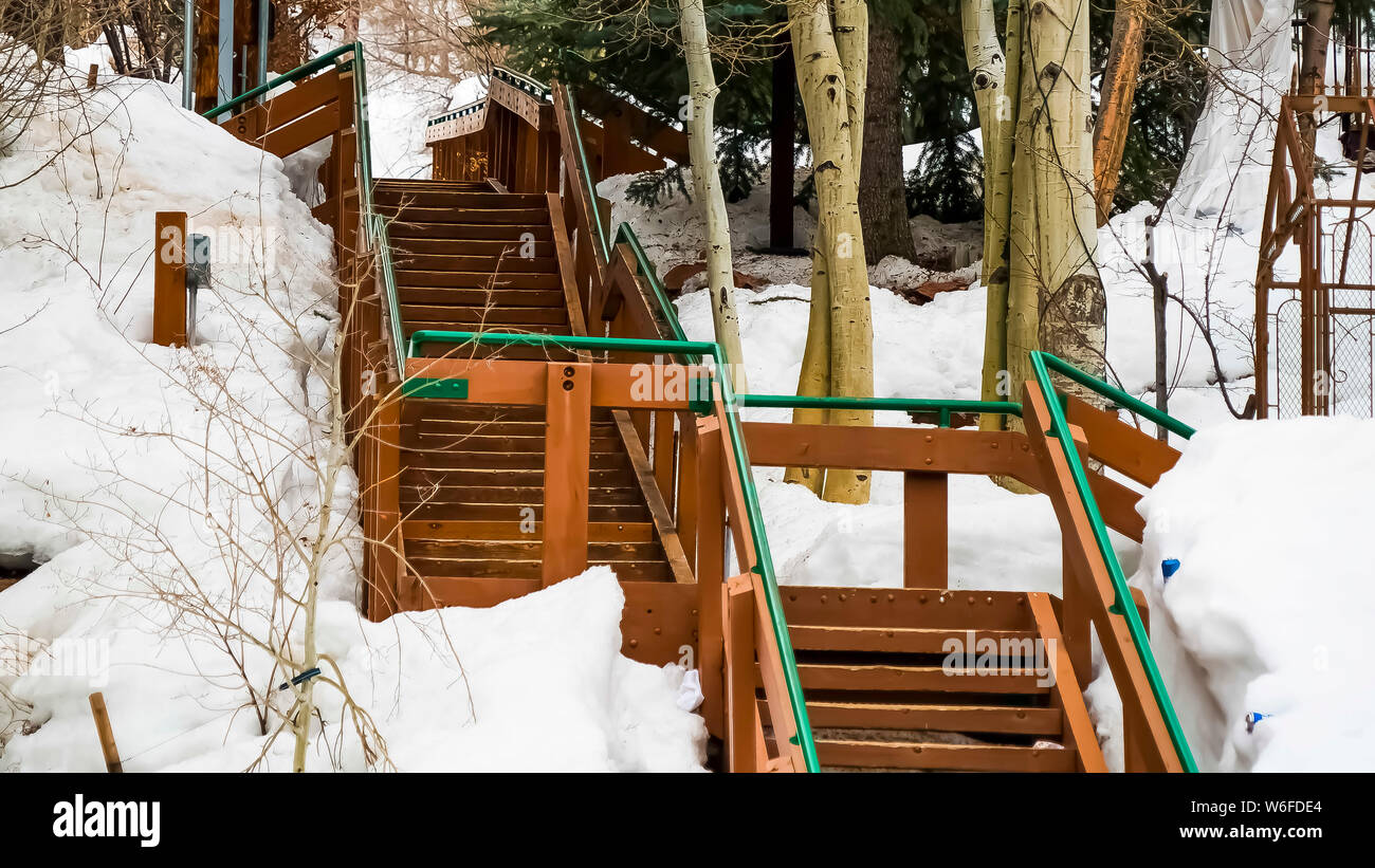 Panorama Outdoor stairs on a mountain slope covered with snow during ...