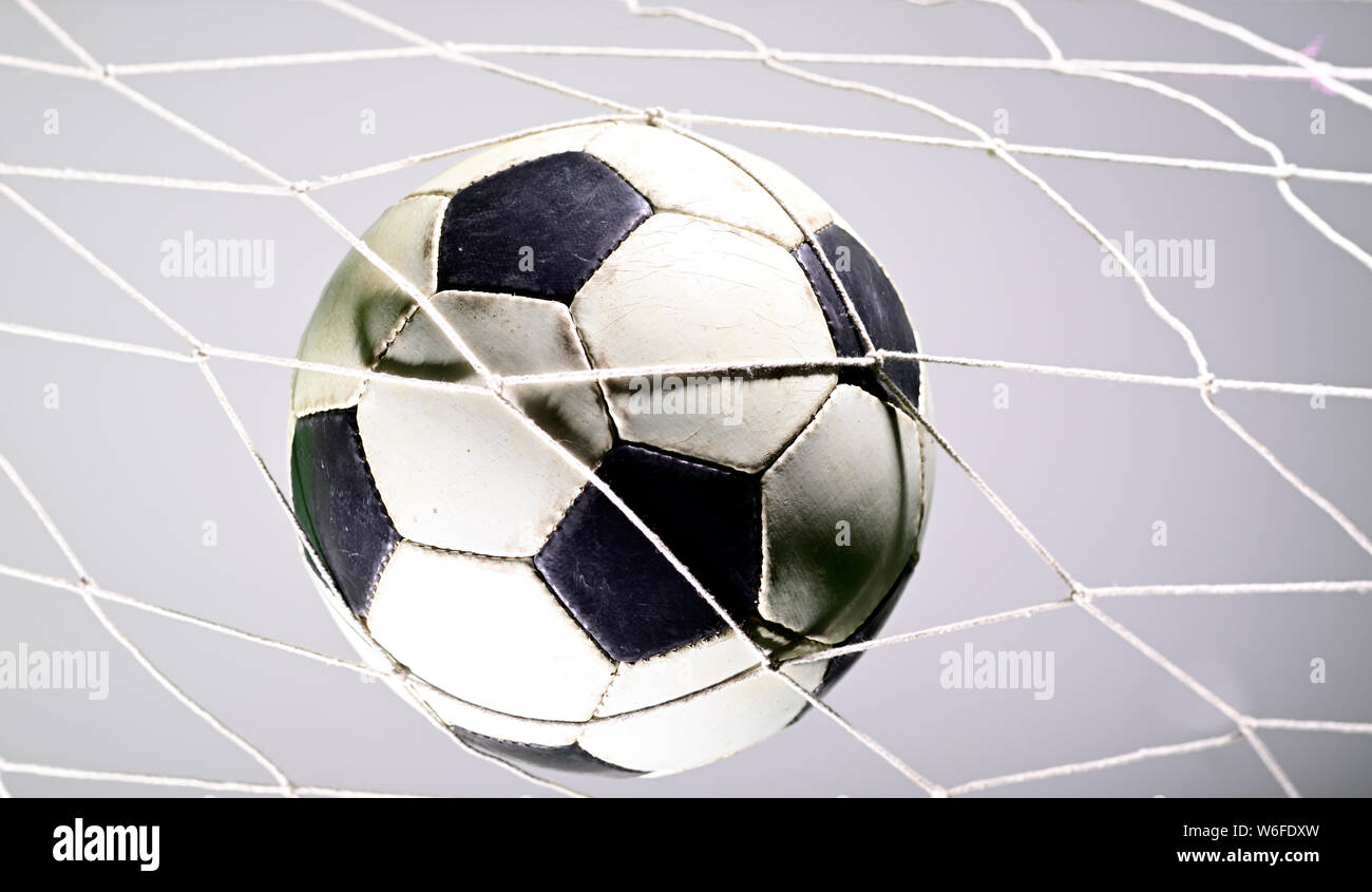 Scoring goal, Soccer ball in the net against gray background Stock ...