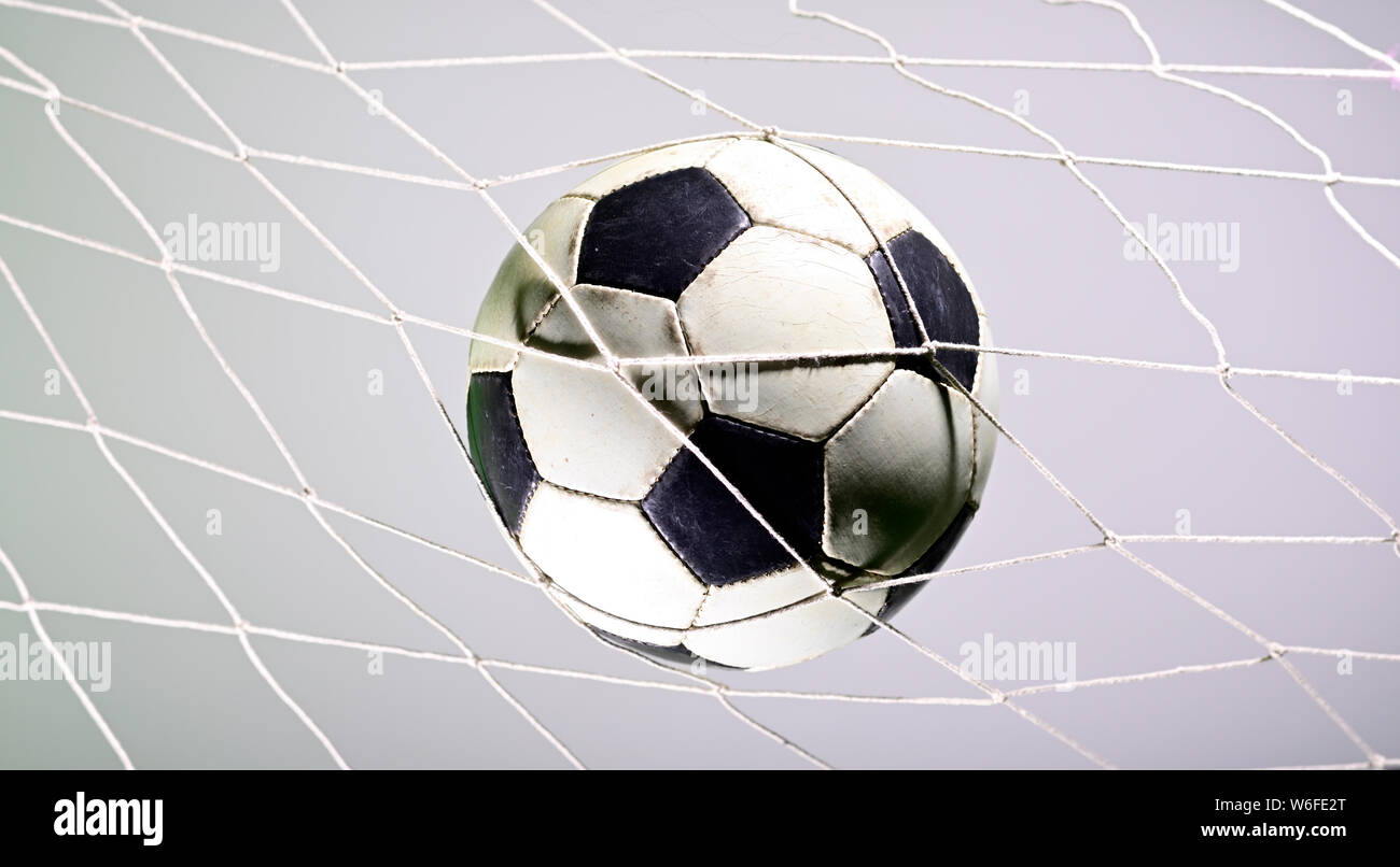 Scoring goal, Soccer ball in the net against gray background Stock ...