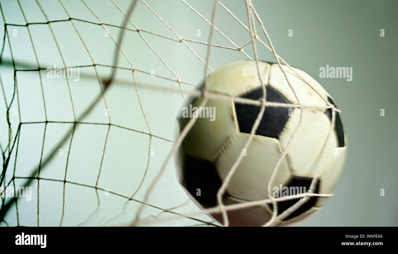 Scoring goal, Soccer ball in the net against gray background Stock ...