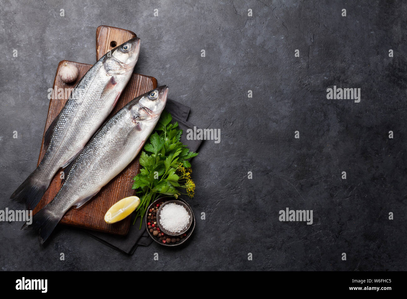 Fresh seafood. Trout fish with herbs and spices on a stone background ...
