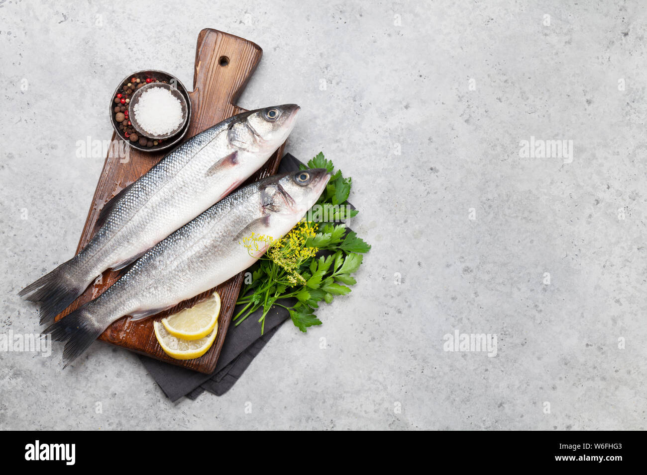 Fresh seafood. Trout fish with herbs and spices on a stone background ...