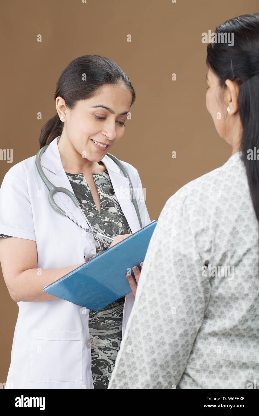 Female doctor writing prescription to patient Stock Photo - Alamy