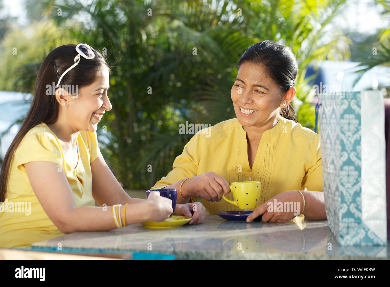 Mother and daughter having cup of tea in a cafeteria Stock Photo - Alamy