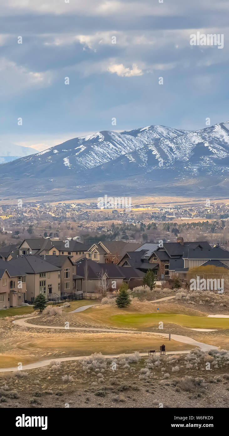Vertical frame Striking snowy mountain towering over the houses built ...