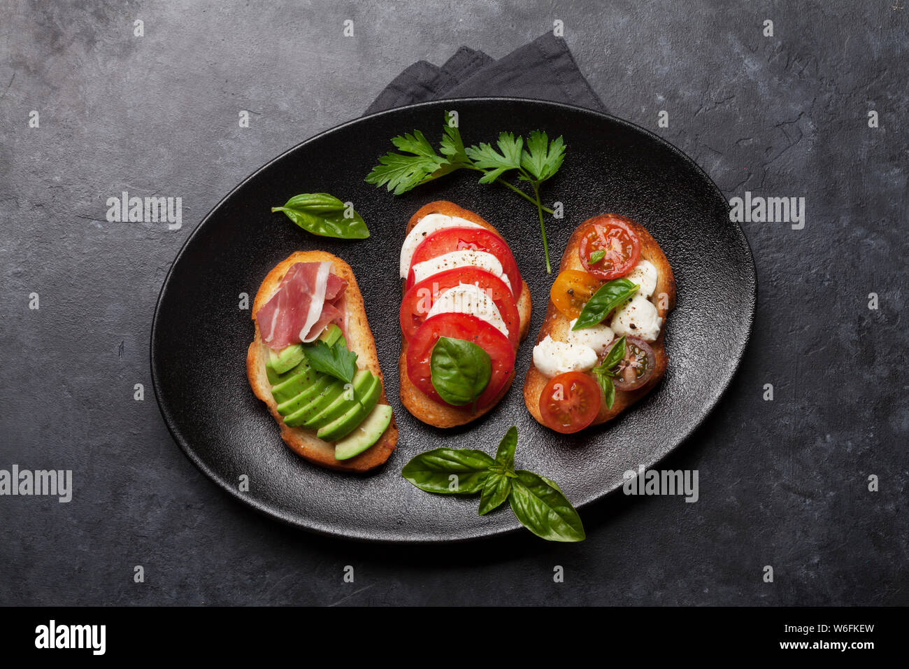 Traditional spanish tapas with tomatoes, mozzarella cheese, avocado and ...