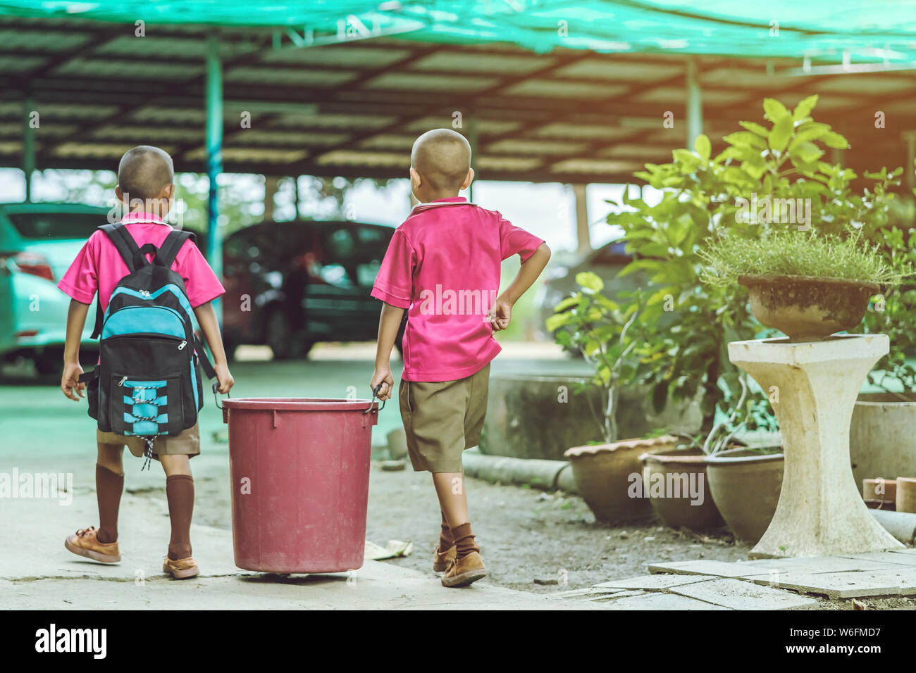 Male Students help to remove rubbish from the classroom to pile waste ...