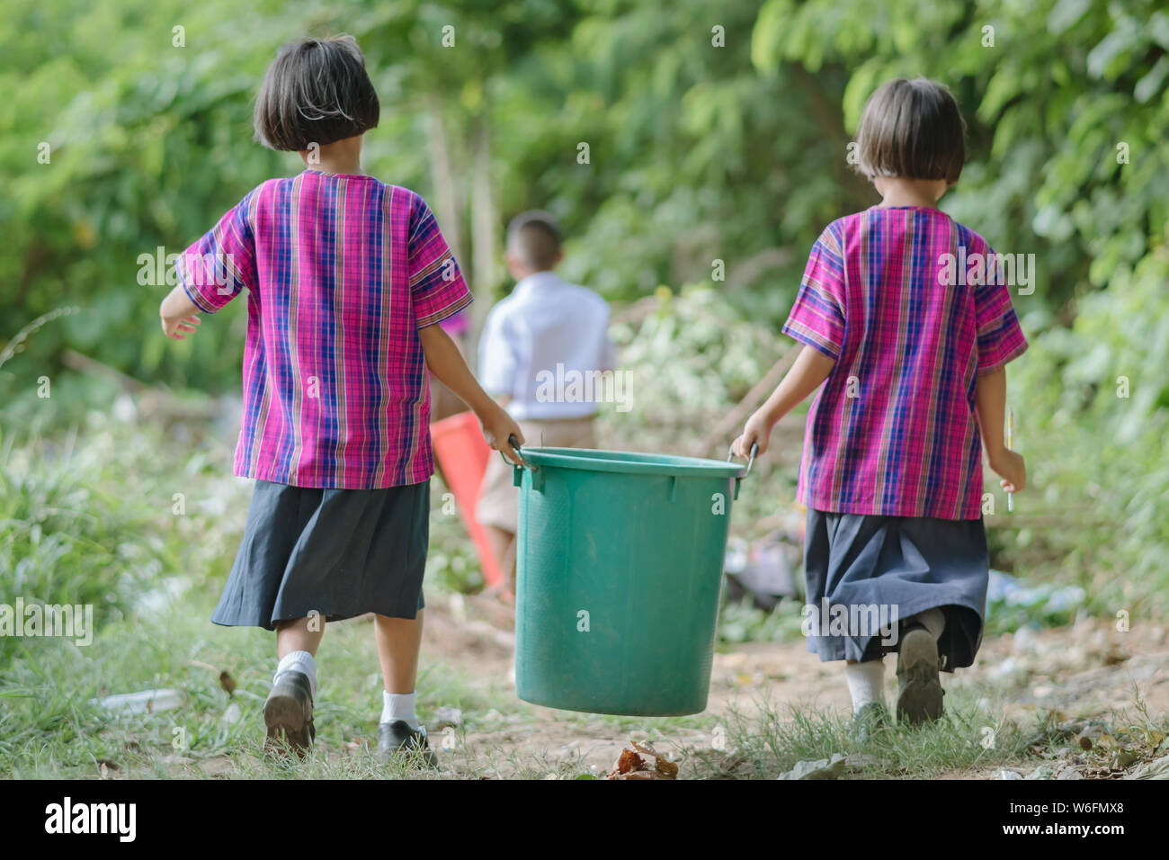 Female Students help to remove rubbish from the classroom to pile waste ...