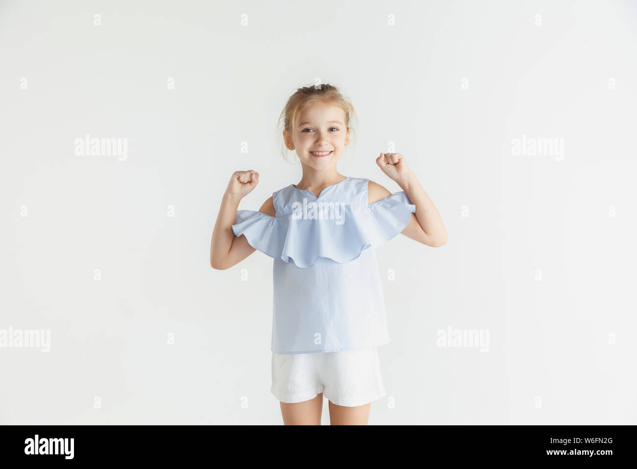 Stylish little smiling girl posing in casual clothes isolated on white ...