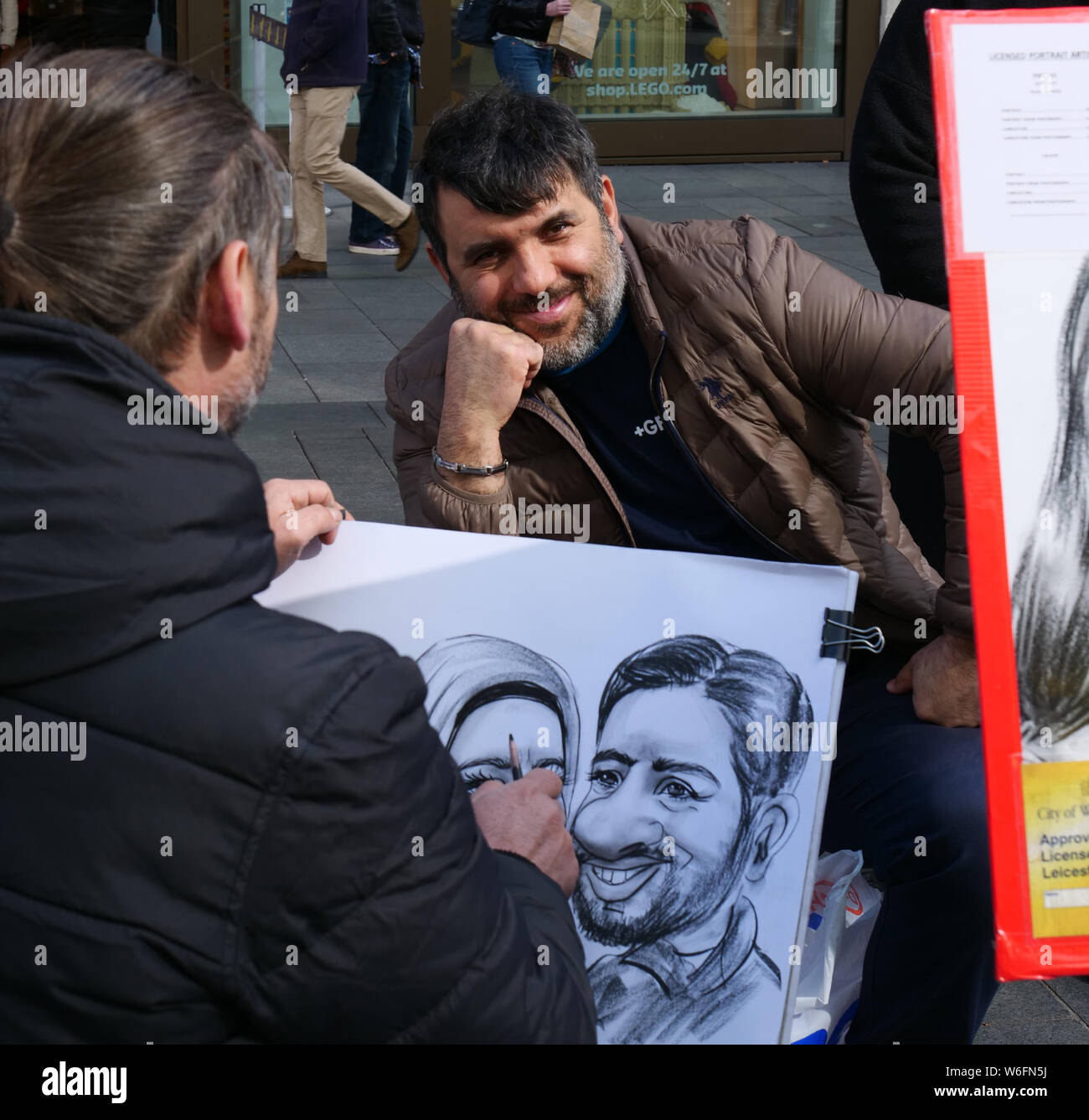 Street artist drawing a caricature of a couple on Leicester Square ...