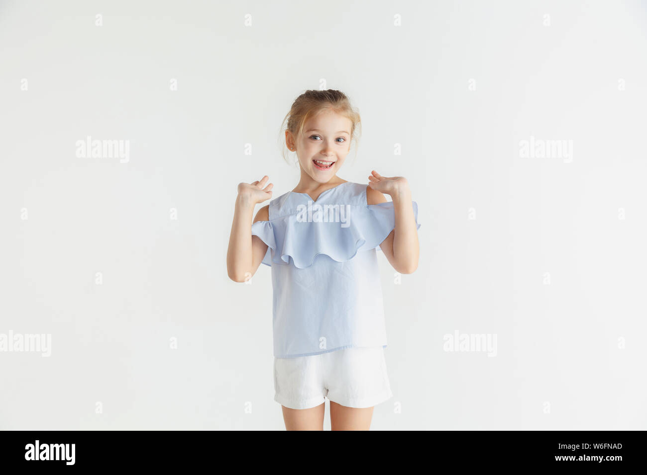 Stylish little smiling girl posing in casual clothes isolated on white ...