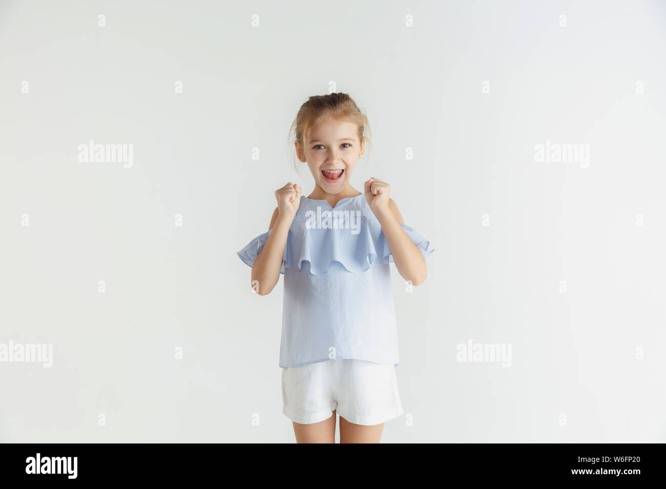 Stylish little smiling girl posing in casual clothes isolated on white ...