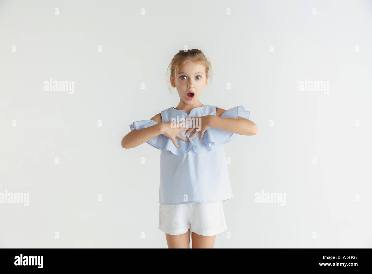 Stylish little smiling girl posing in casual clothes isolated on white ...