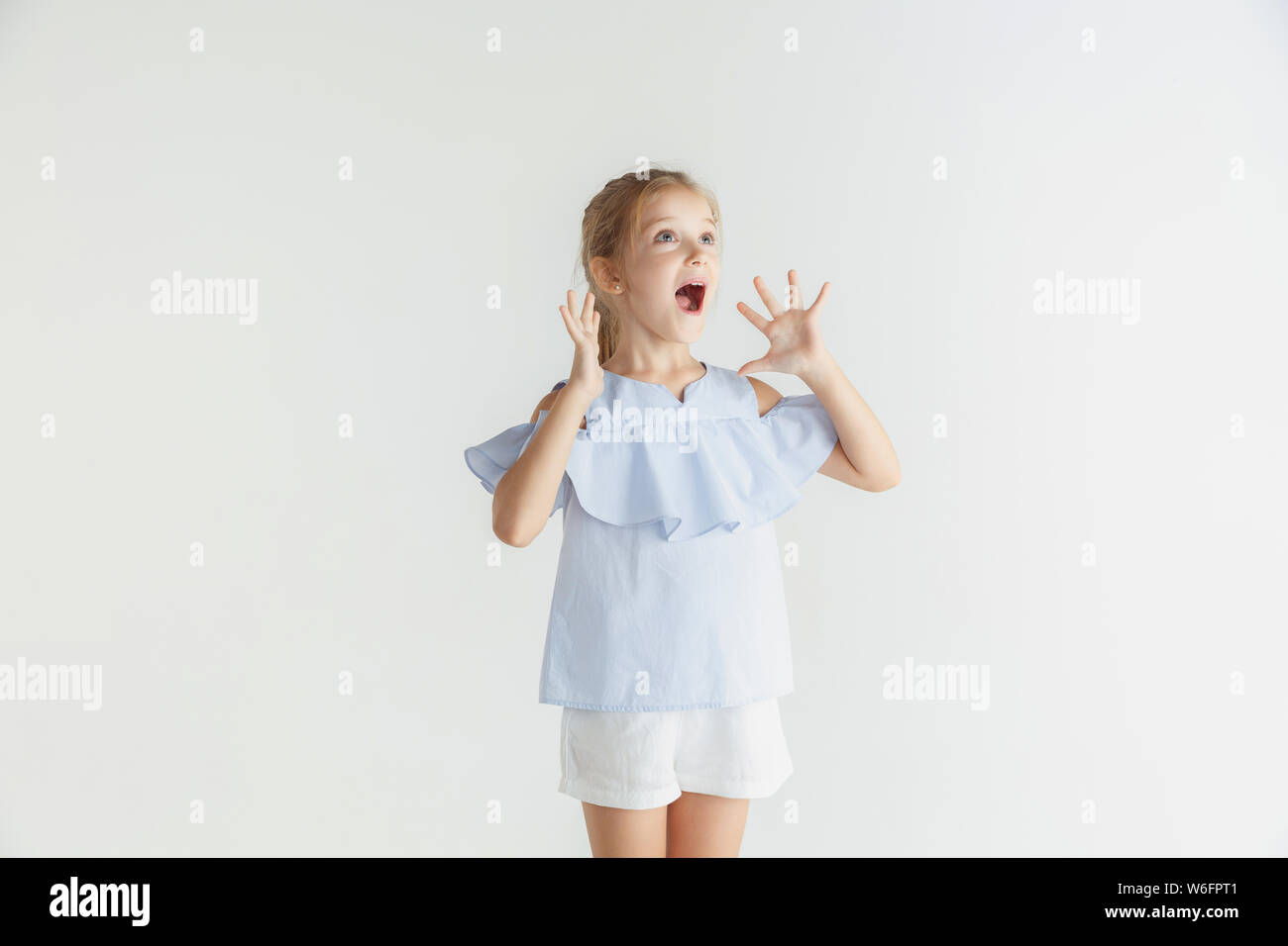 Stylish little smiling girl posing in casual clothes isolated on white ...