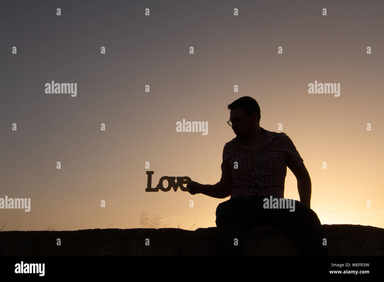 silhouette of man with poster that puts love Stock Photo - Alamy