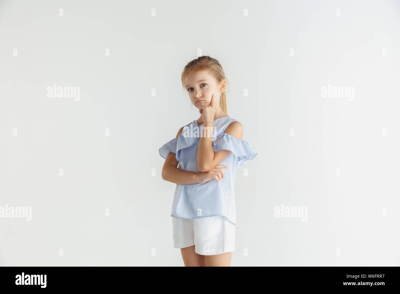 Stylish little smiling girl posing in casual clothes isolated on white ...