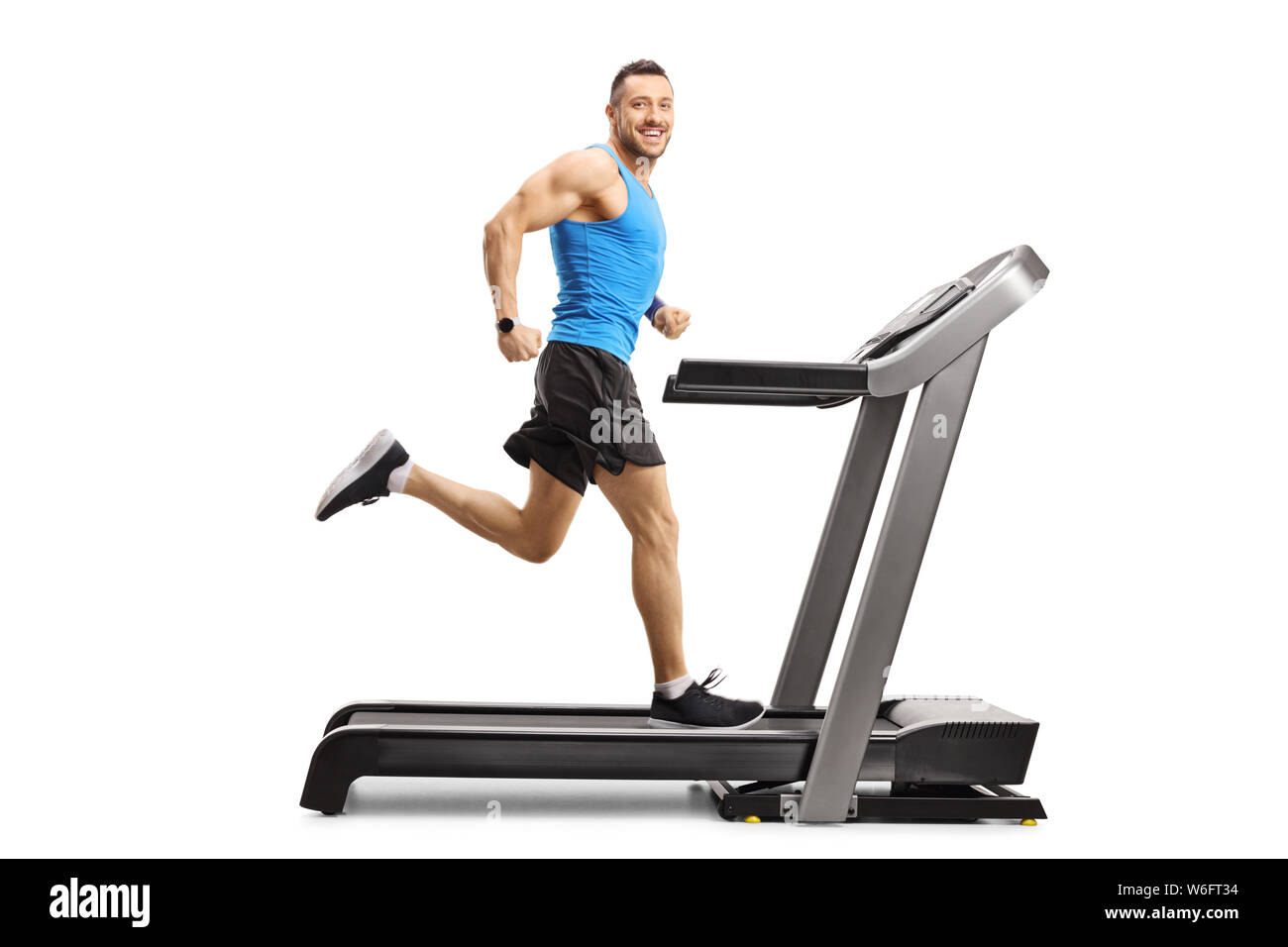 Full length shot of a male athlete running fast on a treadmill isolated ...