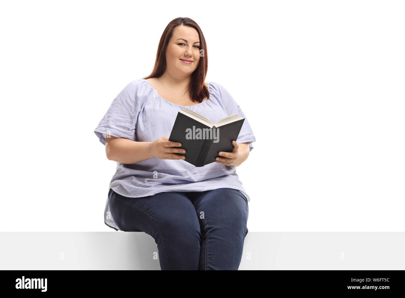 Overweight female reading a book and sitting on a panel isolated on ...