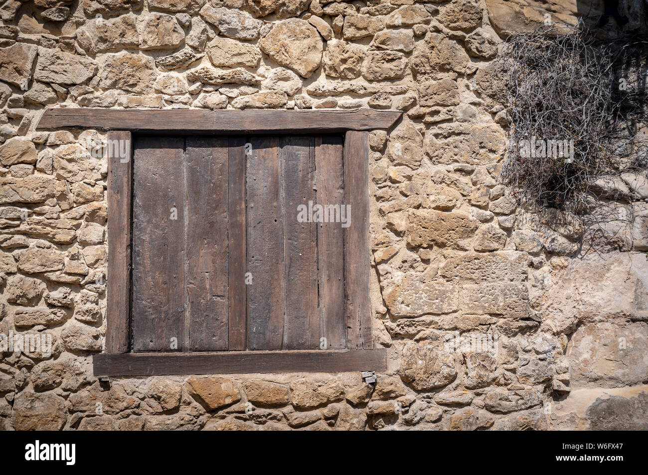 Closed wooden window in stone wall Stock Photo - Alamy