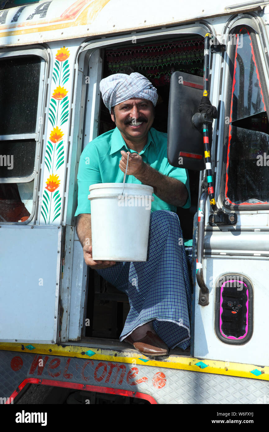 Truck driver showing bucket of motor oil Stock Photo - Alamy