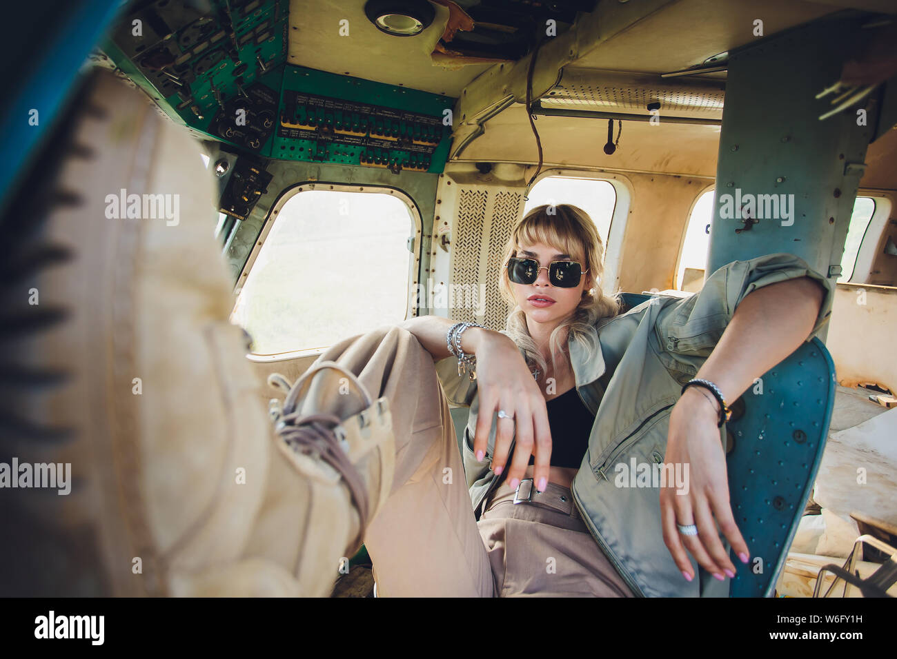 Female pilot in cockpit of helicopter before take off. Young woman ...