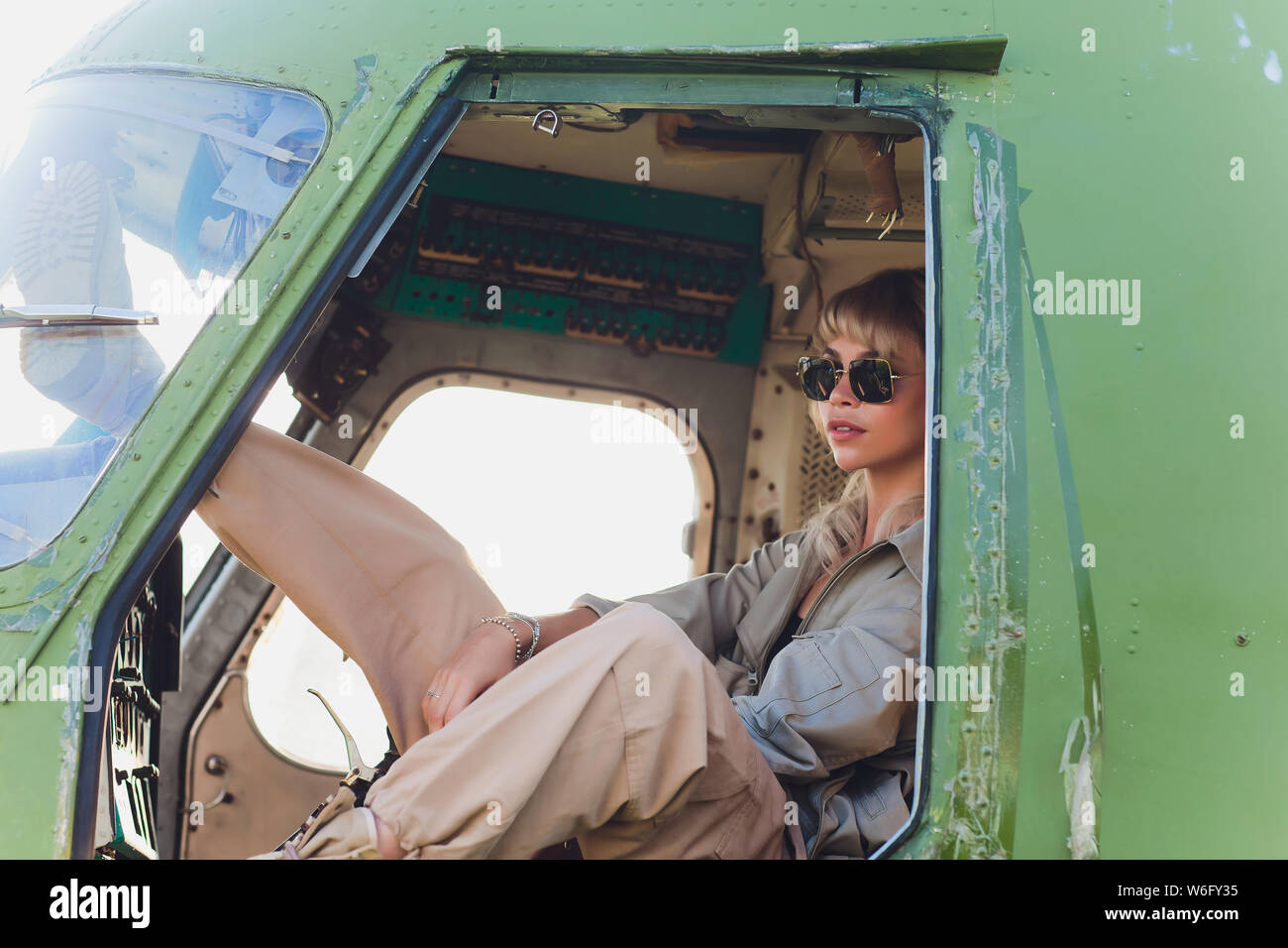 Female pilot in cockpit of helicopter before take off. Young woman ...