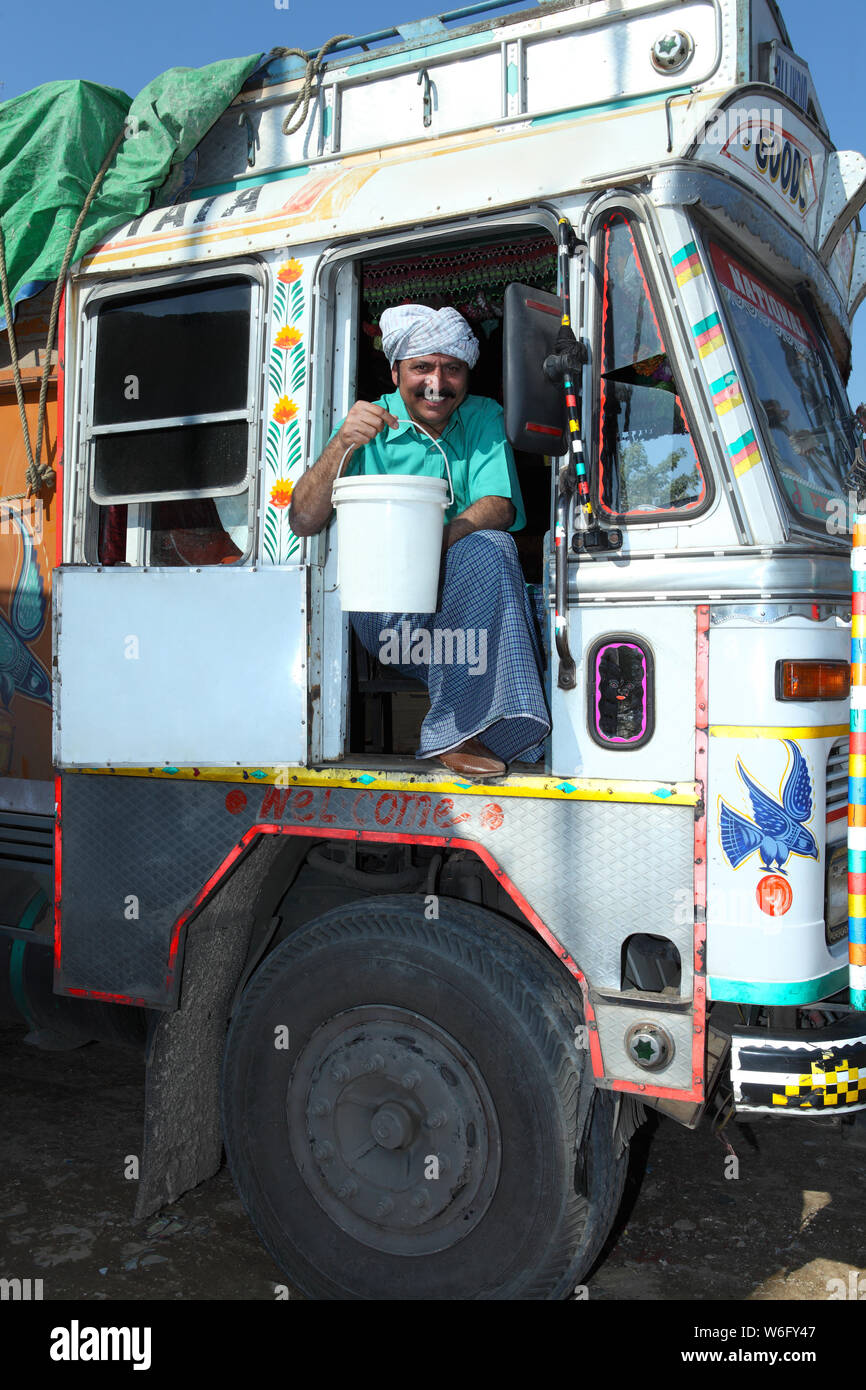 Truck driver showing bucket of motor oil Stock Photo - Alamy