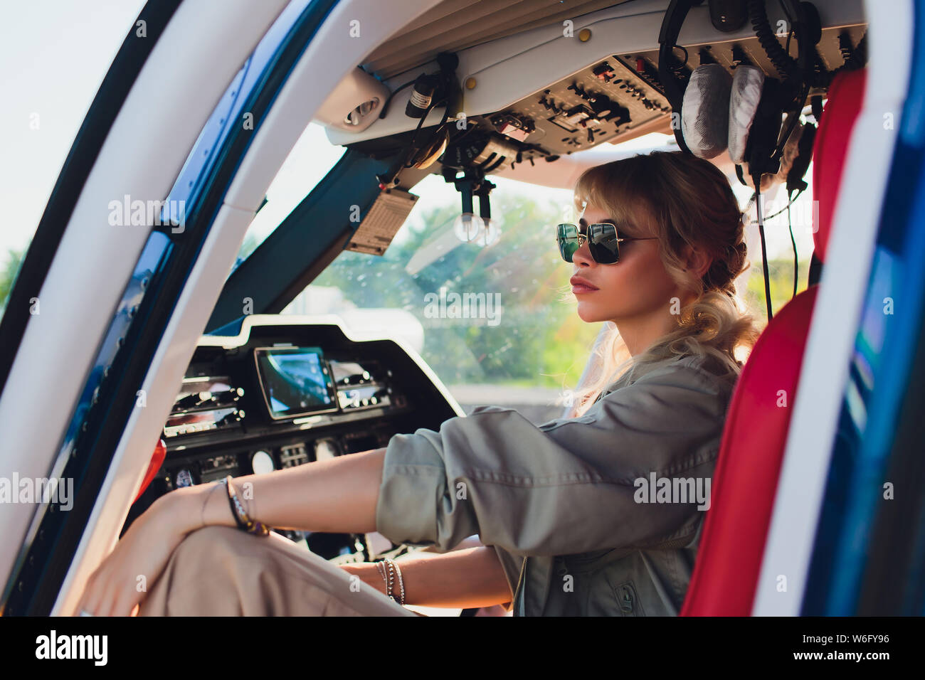 Upbeat mood. Beautiful helicopter pilot smiling cheerfully while ...