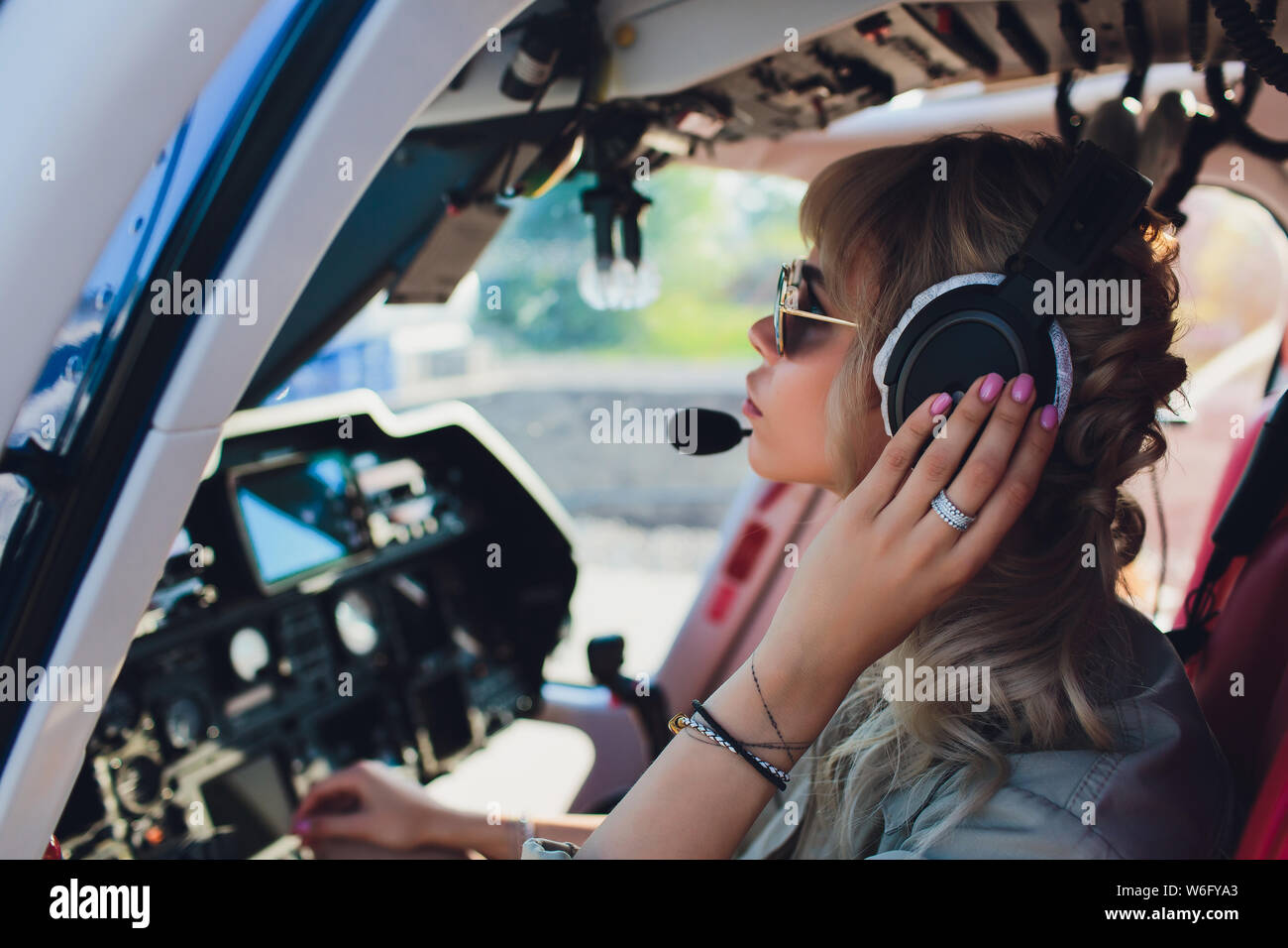 Female pilot in cockpit of helicopter before take off. Young woman helicopter pilot Stock Photo ...