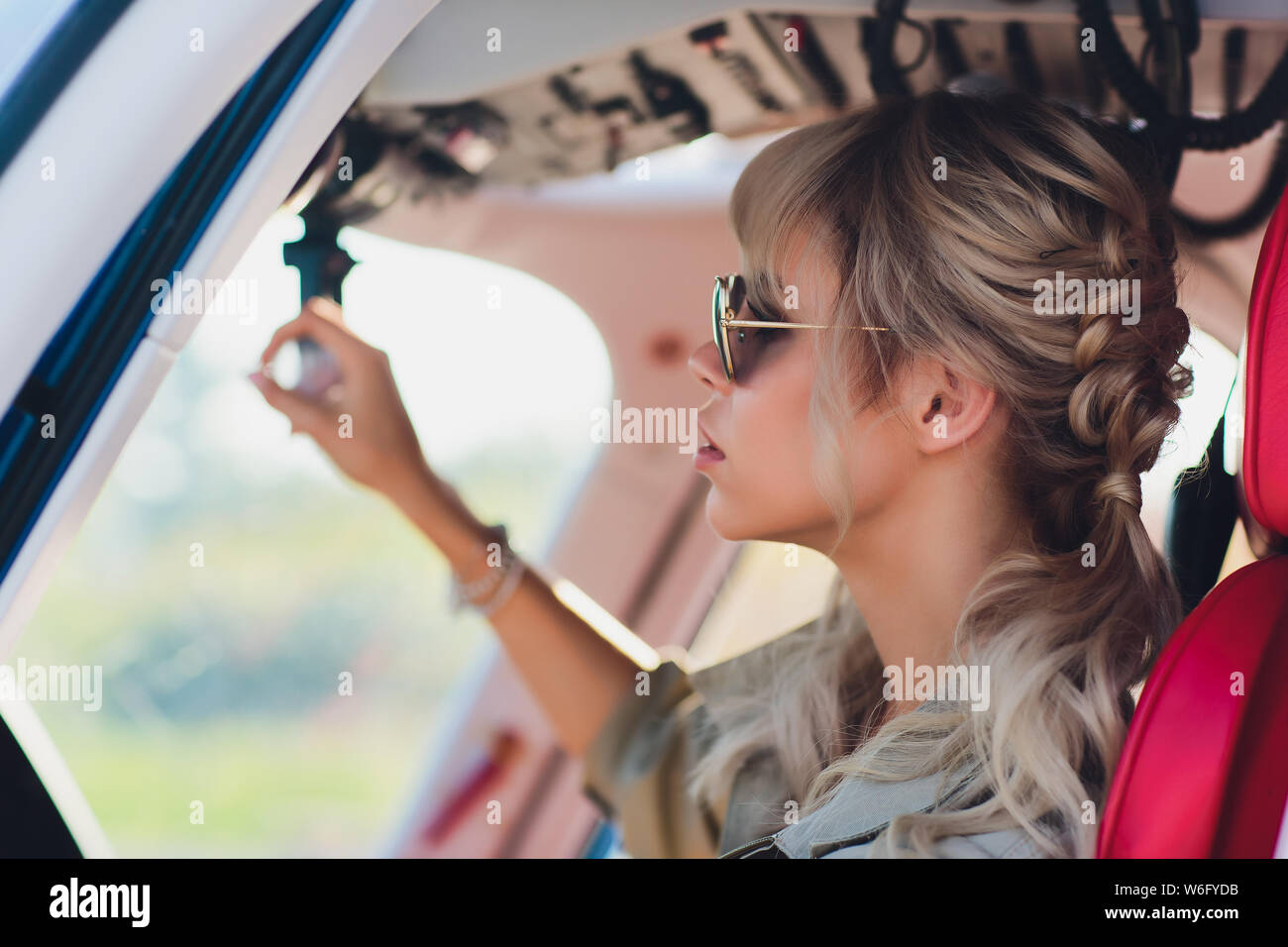 Female pilot in cockpit of helicopter before take off. Young woman ...